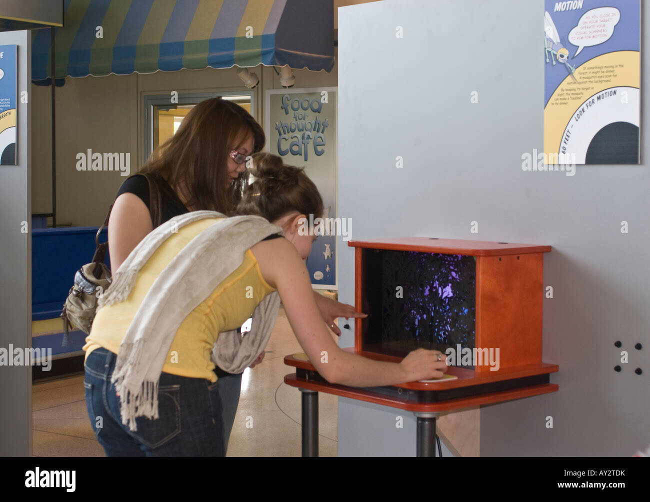 Two female college students looking at an exhibit in a science and ...