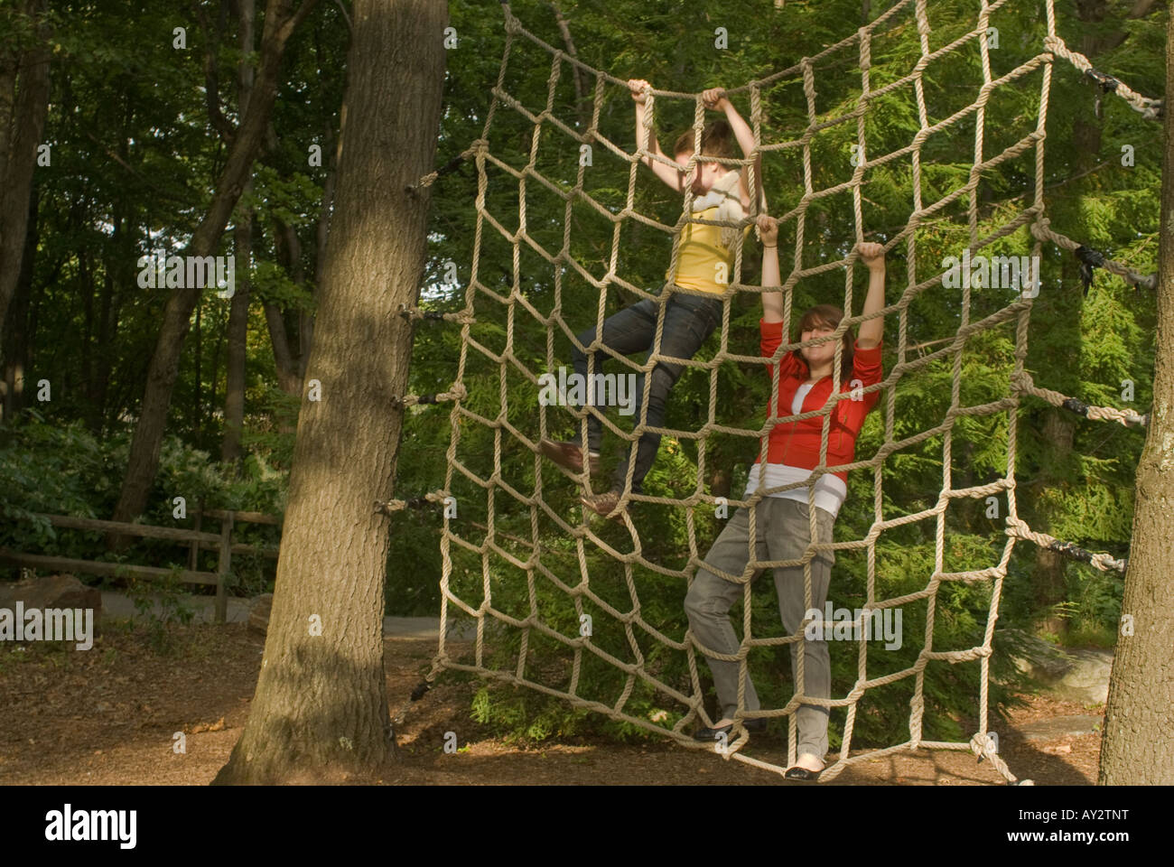 Two 20 year old female college students having fun on a rope climb ...