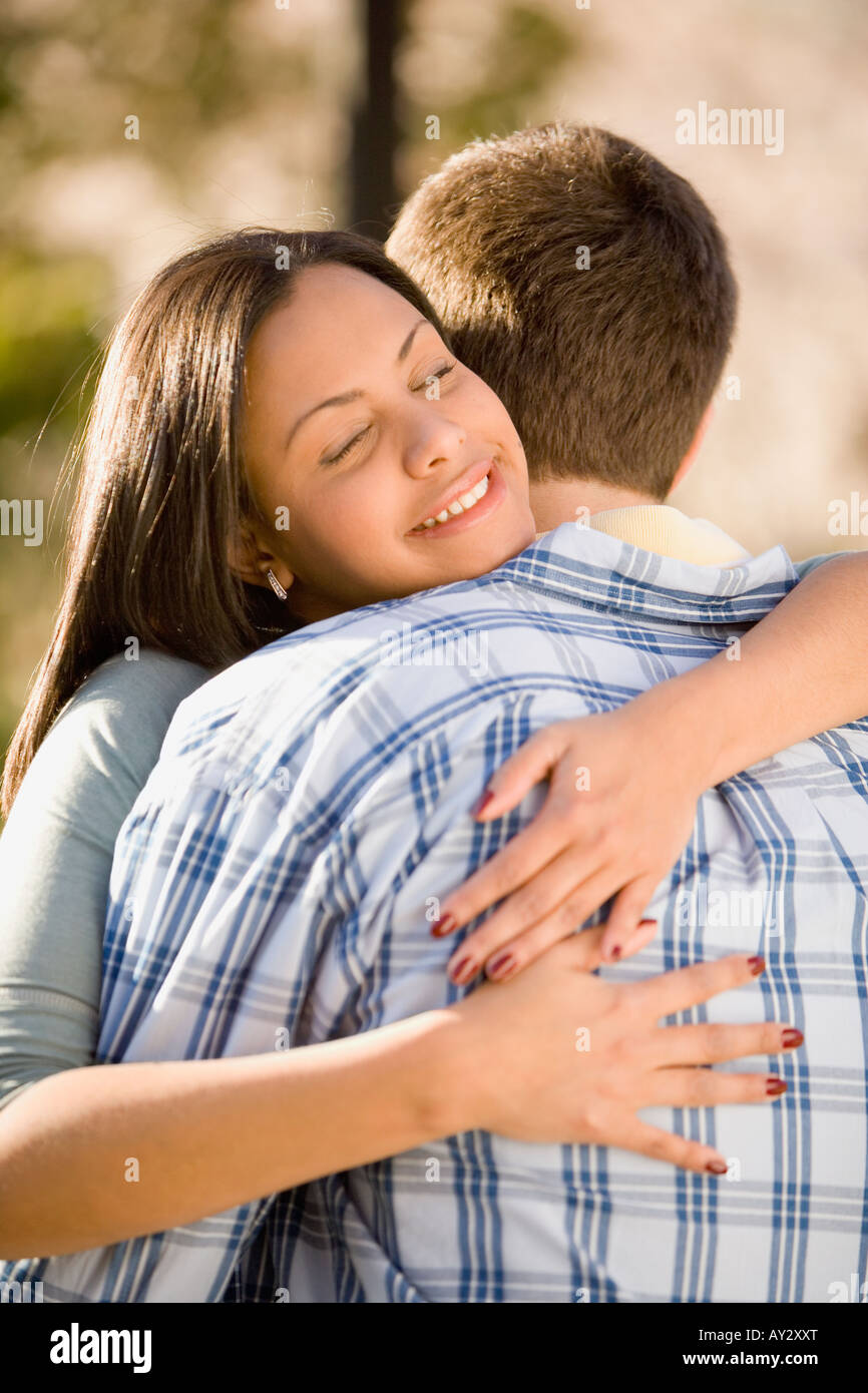 Hispanic woman hugging boyfriend Stock Photo - Alamy