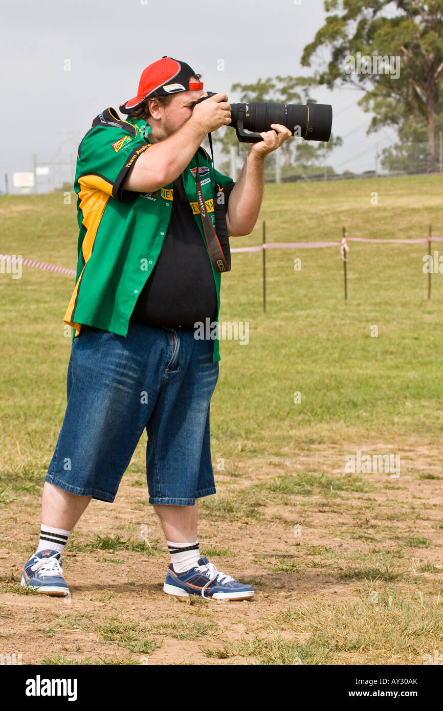 A young photographer using a zoom lens on an SLR camera Stock Photo - Alamy