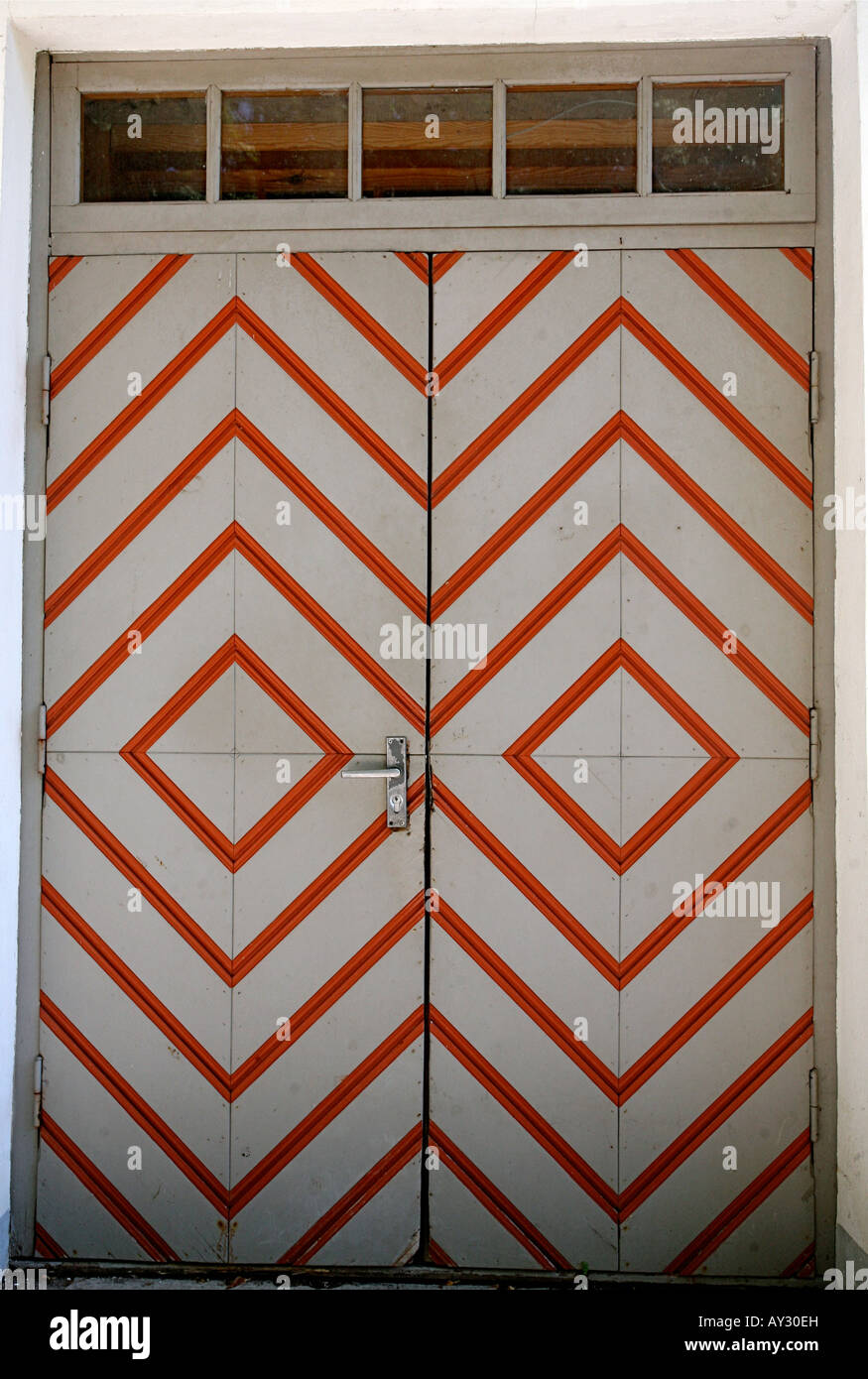 red and white wood door with diamond pattern with decoration above door ...