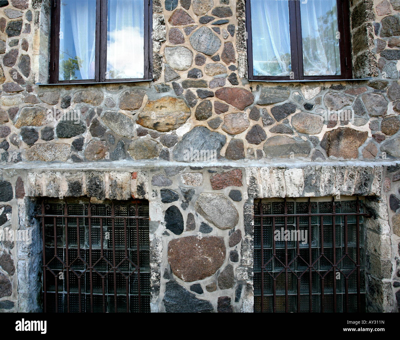 Four windows in an old stone building. Bottom windows at ground level ...