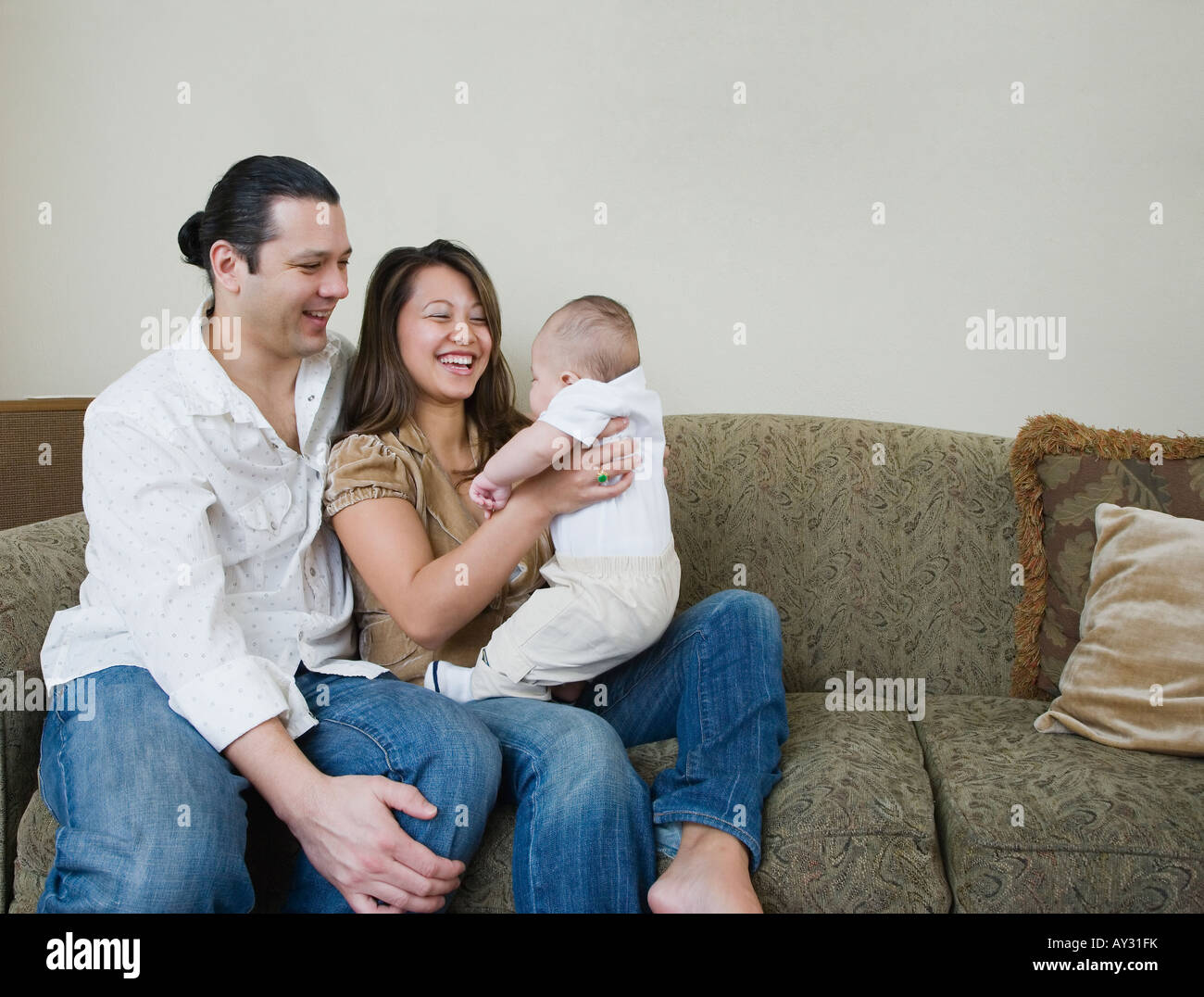 Asian parents smiling at baby Stock Photo - Alamy