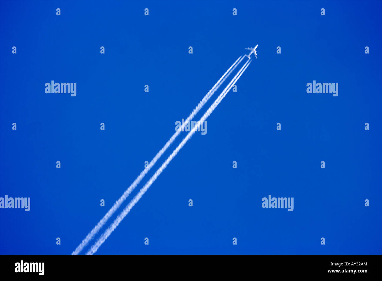 Jet trails against a blue sky Stock Photo - Alamy