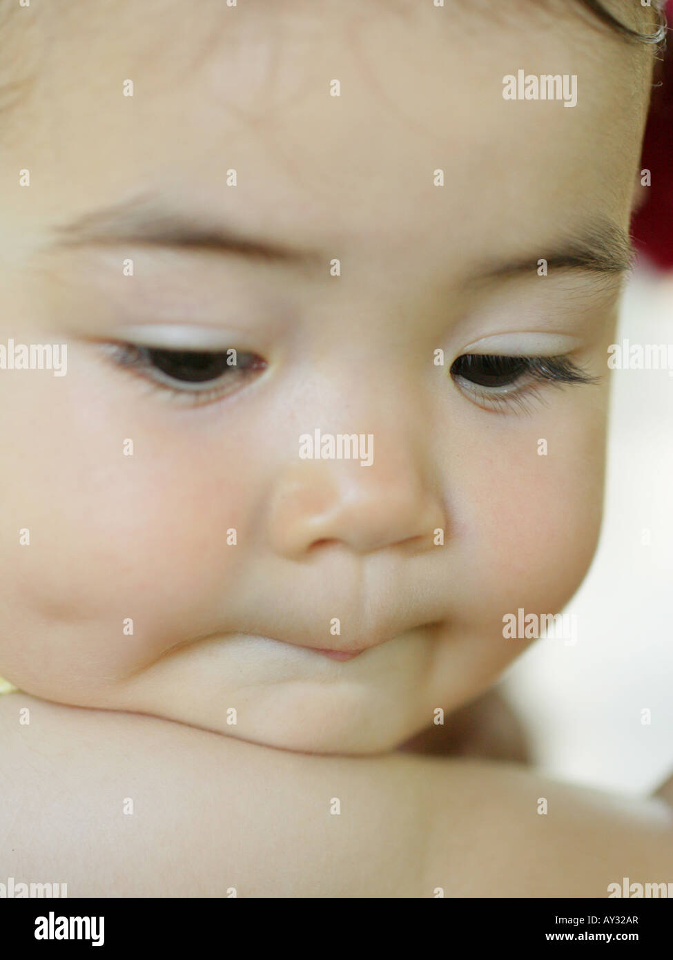 Close-up of a baby girl looking down Stock Photo - Alamy
