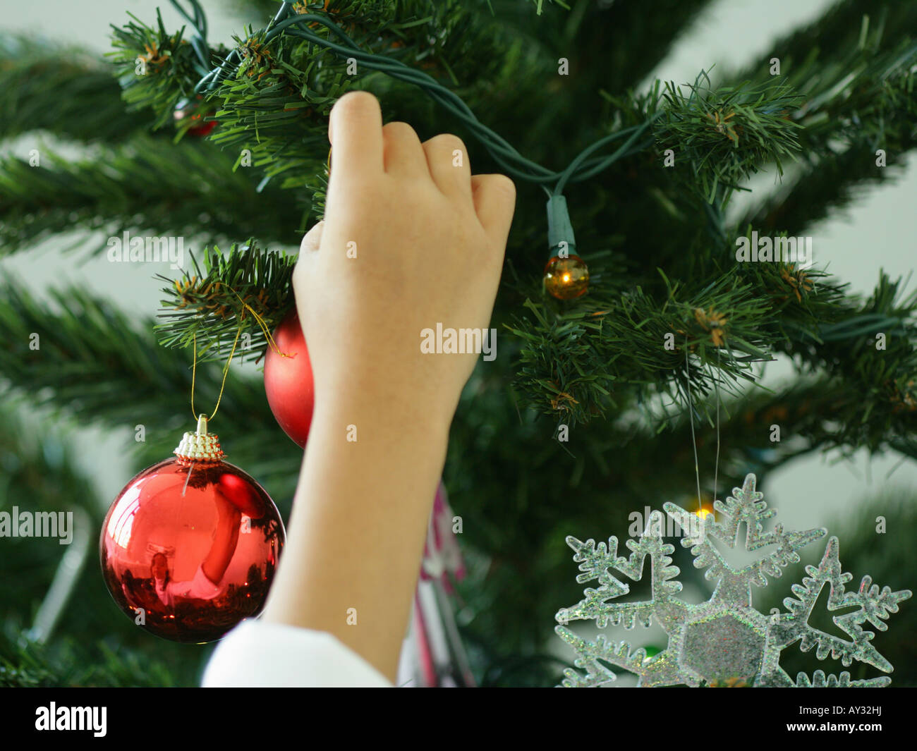 Close-up of a child's hand decorating a Christmas tree Stock Photo - Alamy