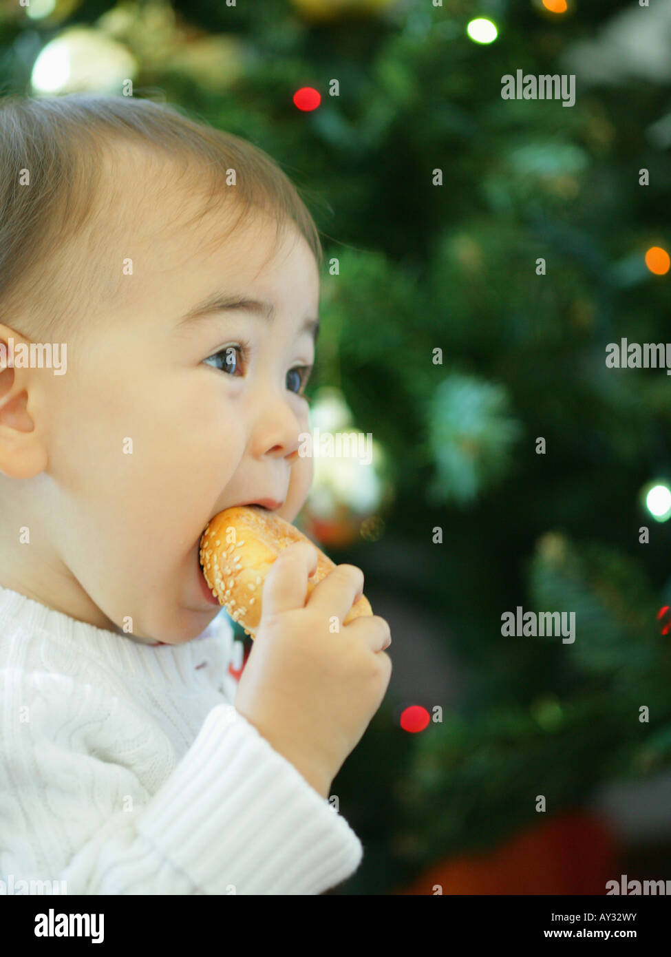 Side profile of a baby girl eating a donut Stock Photo - Alamy