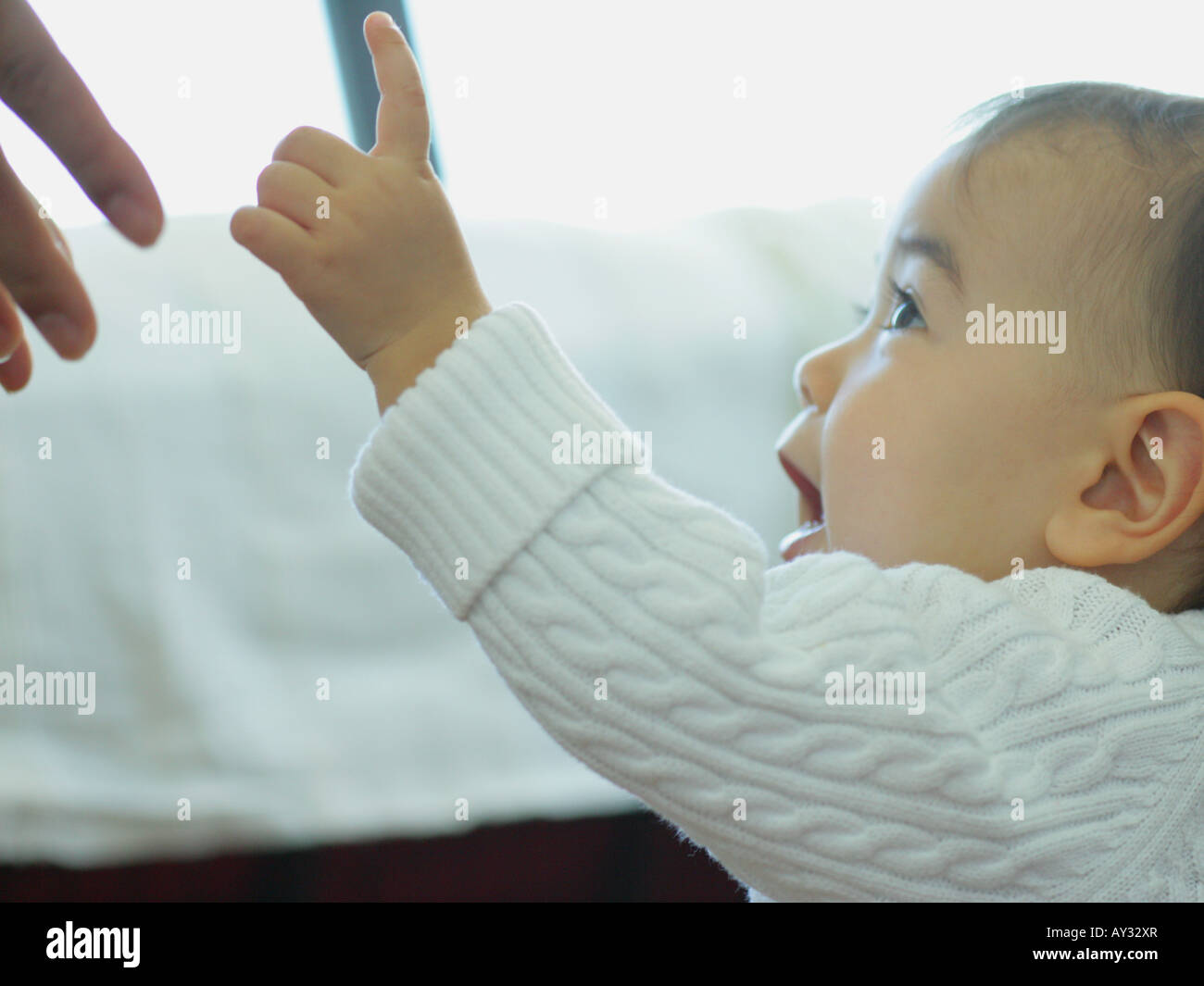 Side profile of a baby girl with her arm outstretched Stock Photo - Alamy