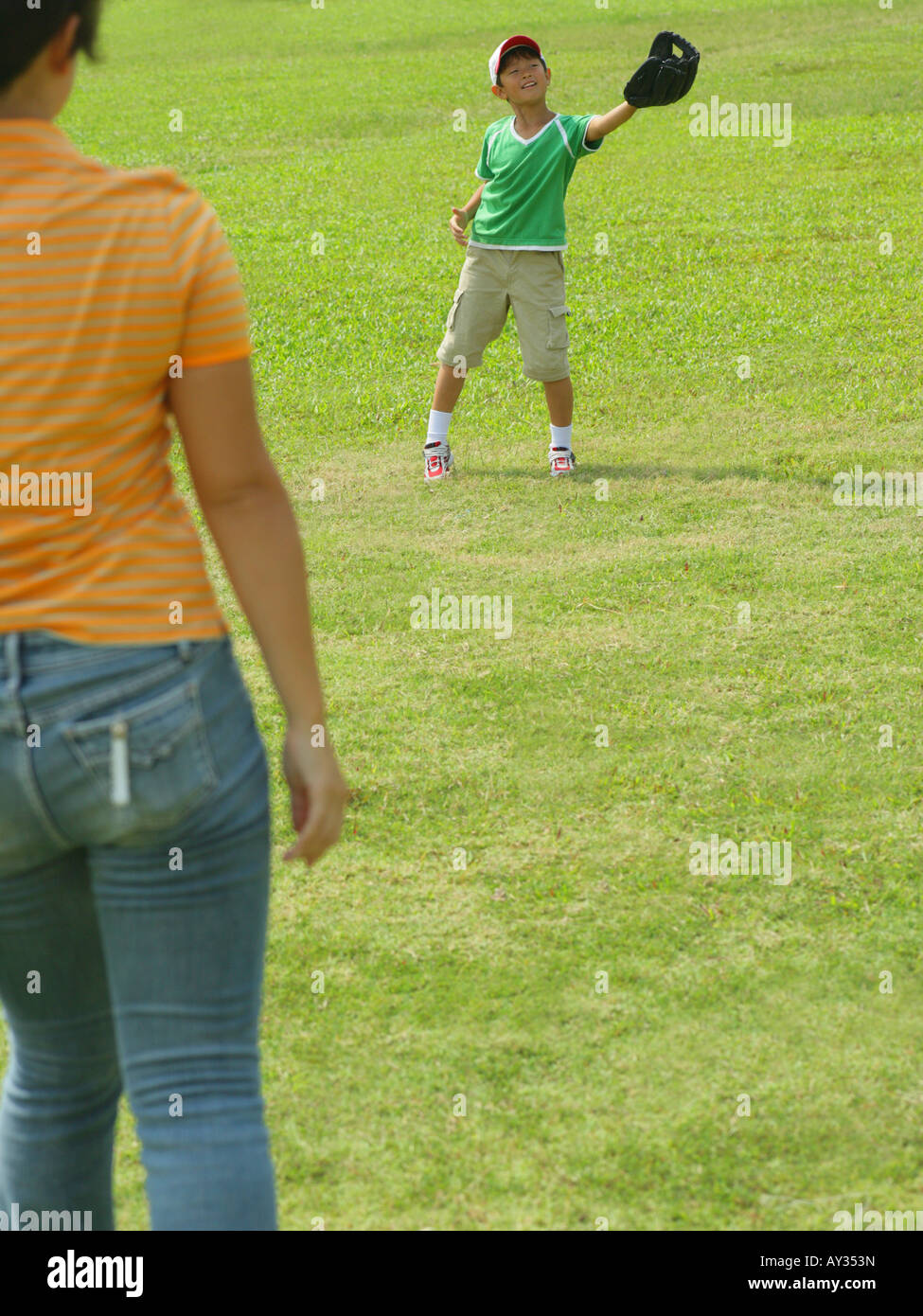 Rear view of a woman playing catch with her son Stock Photo - Alamy
