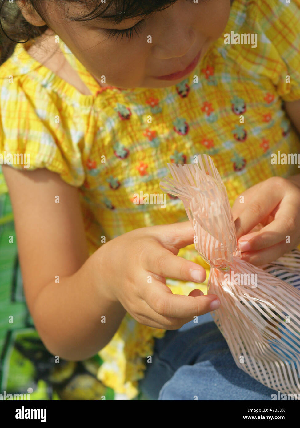 Close-up of a girl opening a plastic bag Stock Photo - Alamy