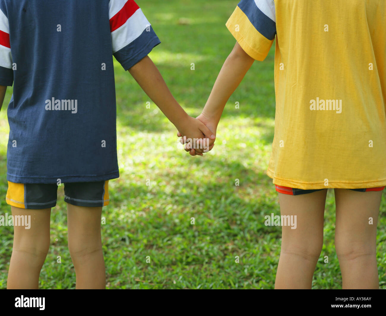 Mid section view of two boys holding hands Stock Photo - Alamy