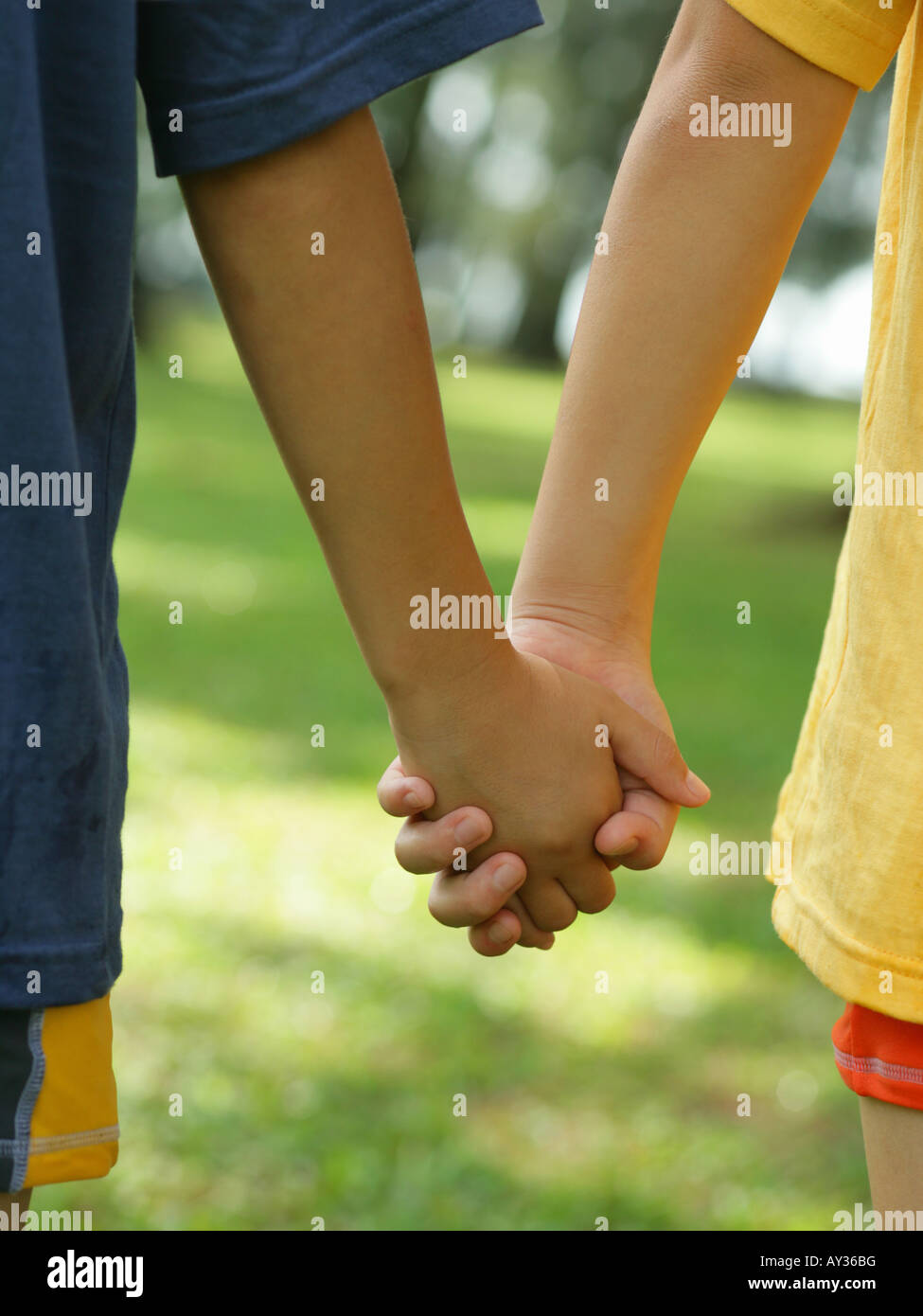 Mid section view of two boys holding hands Stock Photo - Alamy