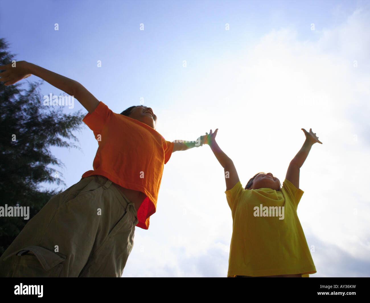 Low angle view of two boys with their arms raised Stock Photo - Alamy