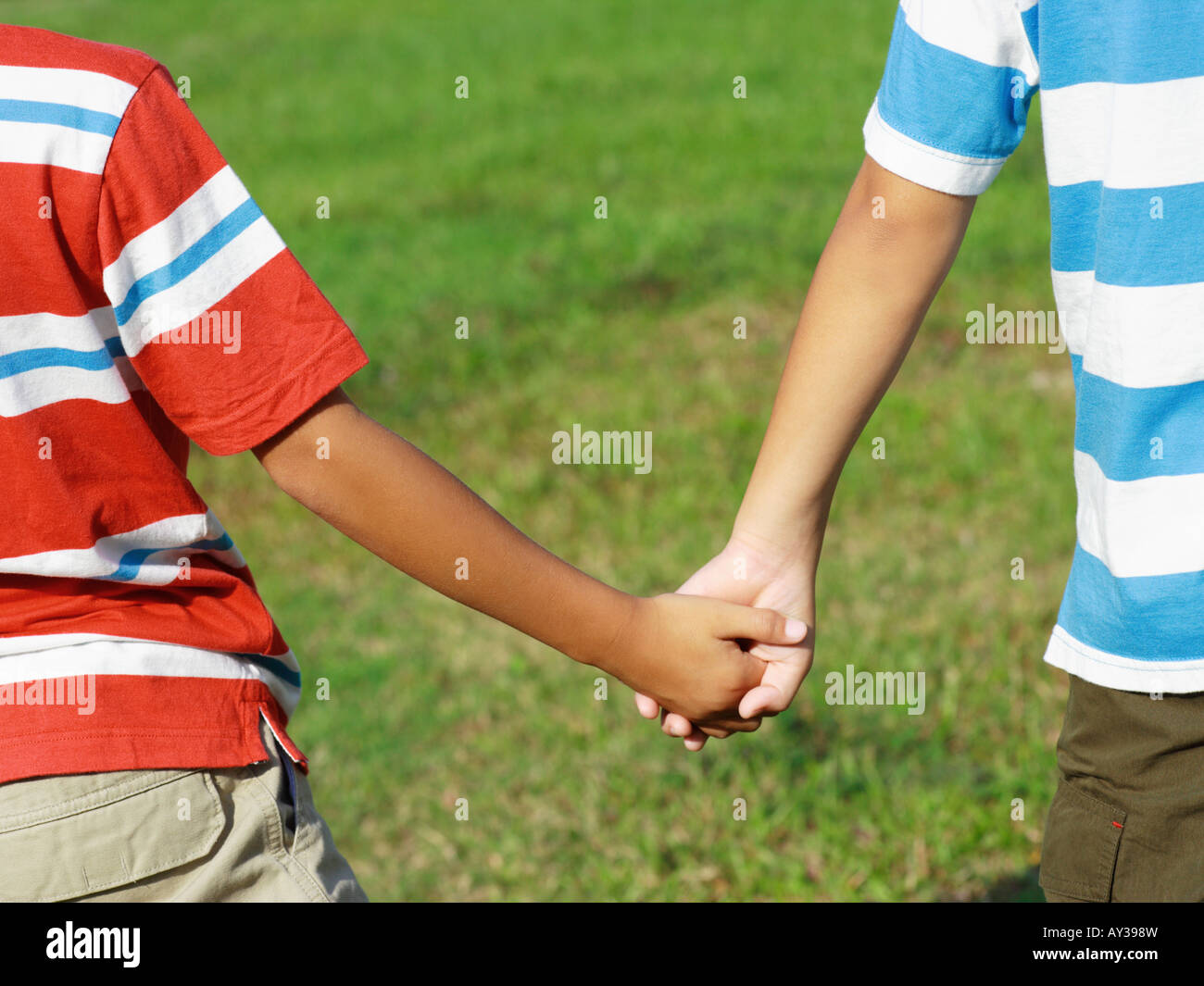 Mid section view of two boys holding each other's hands Stock Photo - Alamy
