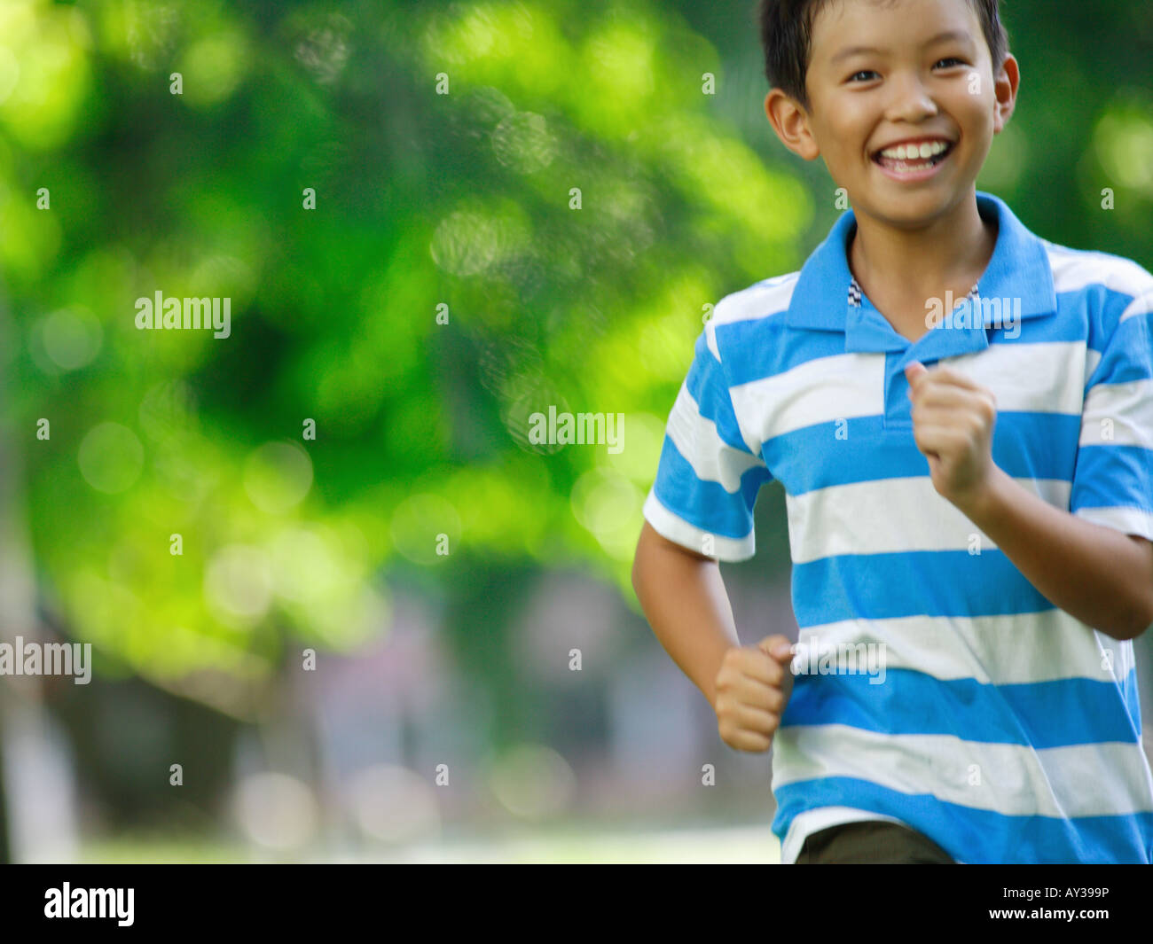 Portrait of a boy running and smiling Stock Photo - Alamy