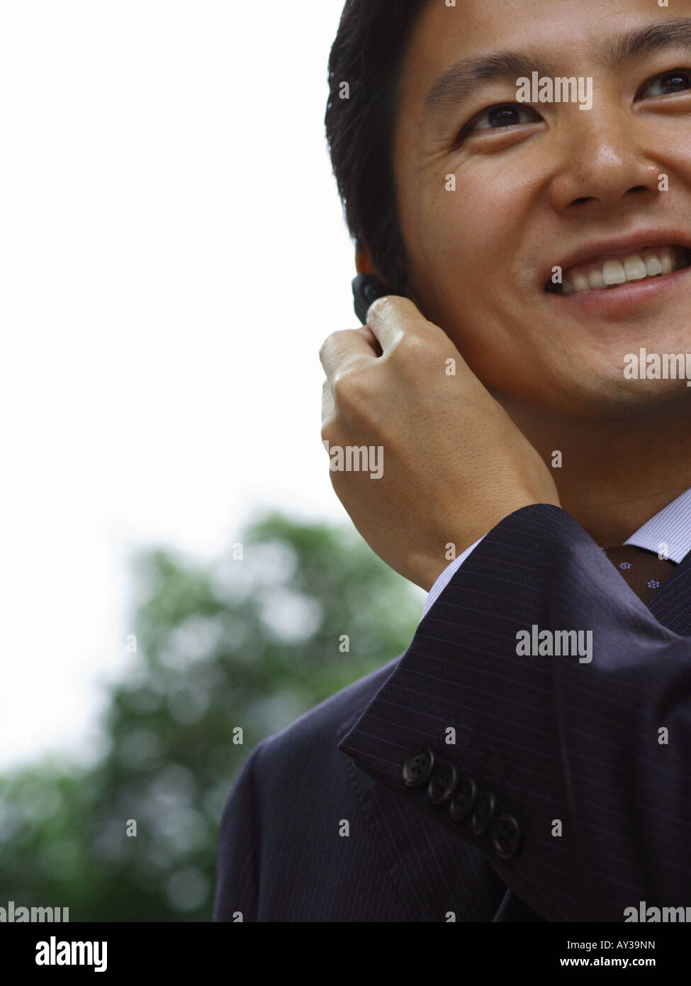Close-up of a businessman using a bluetooth device and smiling Stock ...