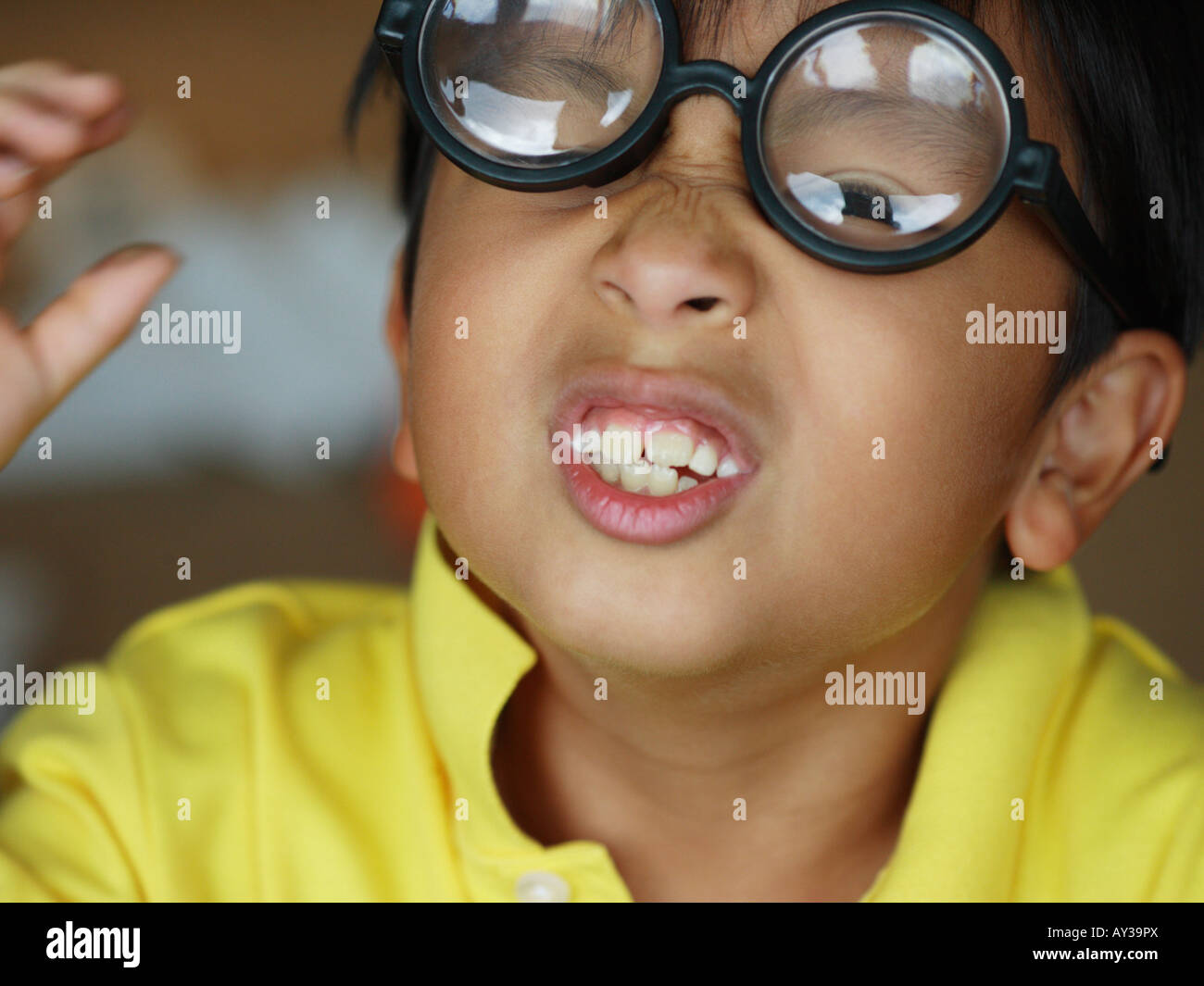 Portrait of a boy wearing glasses and making a face Stock Photo - Alamy
