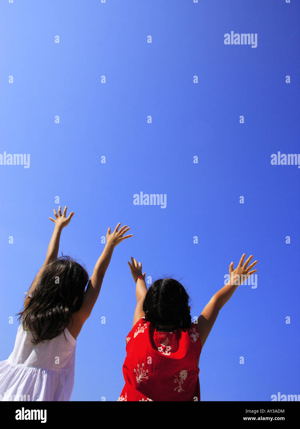 Rear view of two girls standing with their arms raised Stock Photo - Alamy