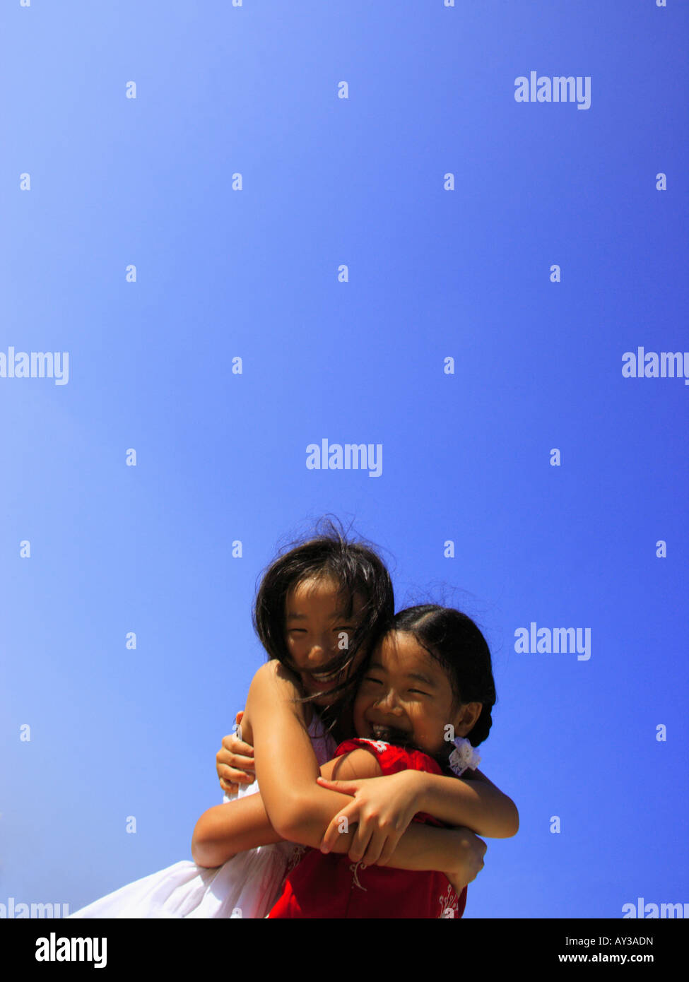 Side profile of two girls hugging each other and smiling Stock Photo ...