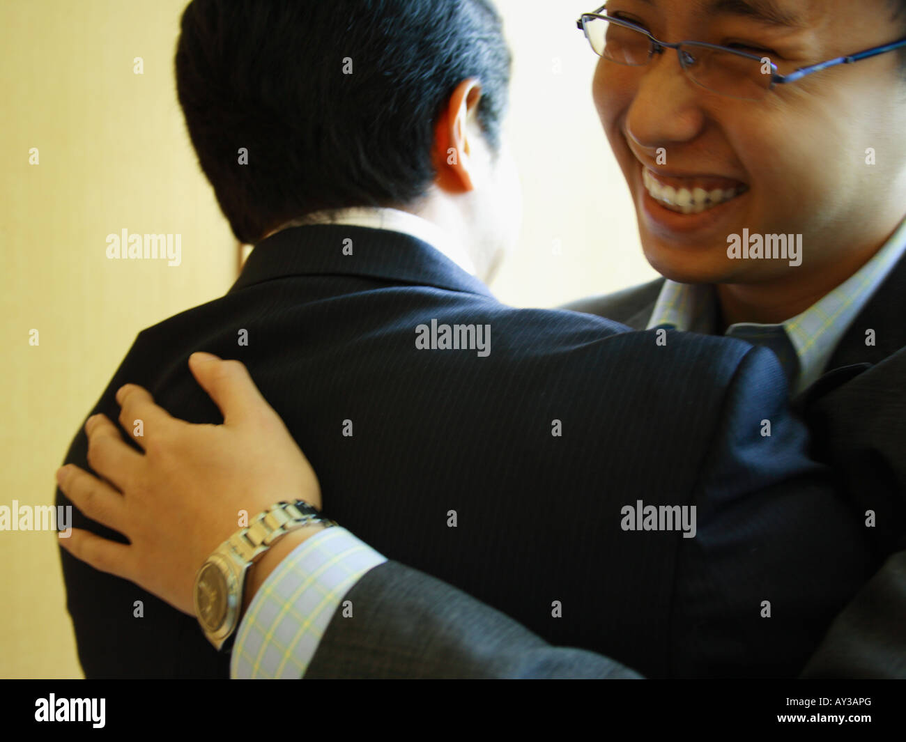 Close-up of two businessmen hugging each other Stock Photo - Alamy
