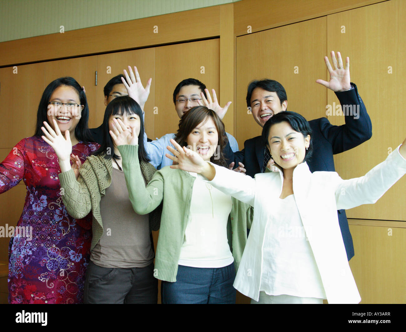 Portrait of a group of business executives waving their hands and ...