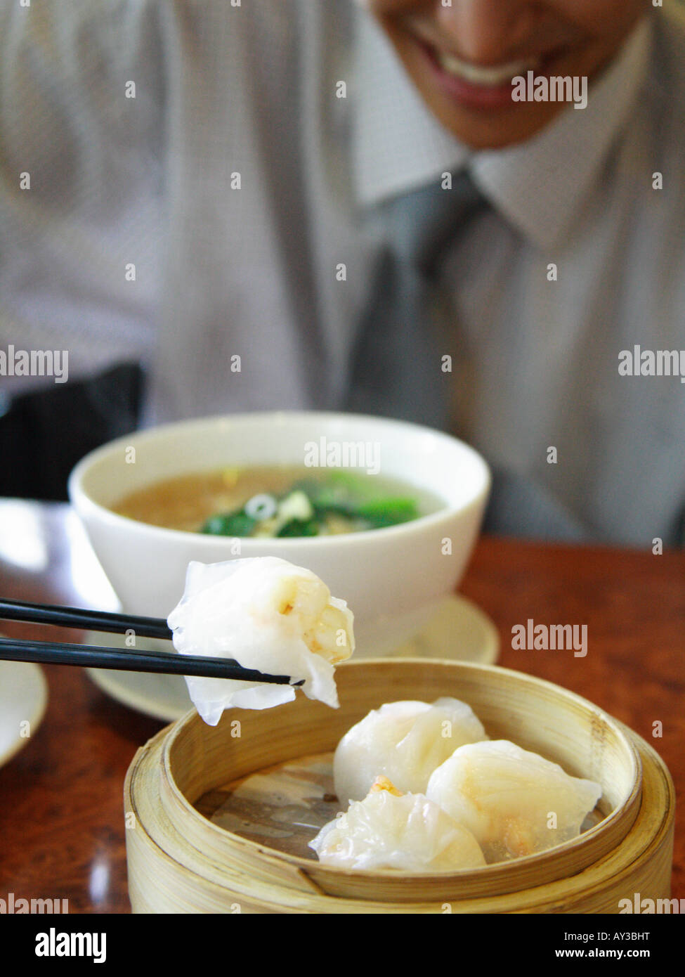 Young man eating Chinese food with chopsticks Stock Photo - Alamy