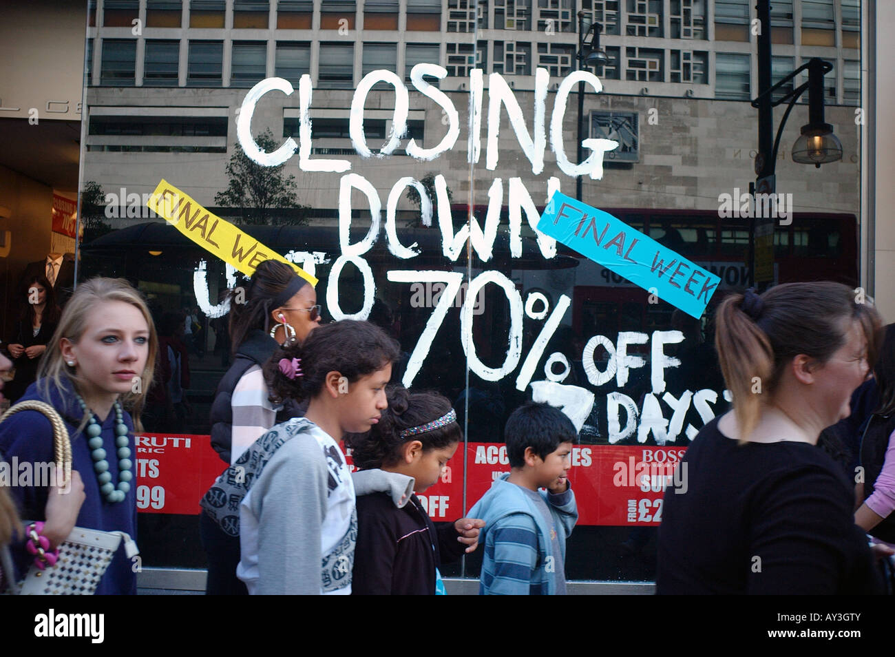 Shoppers in Oxford Street London walking past a shop closing down Stock ...