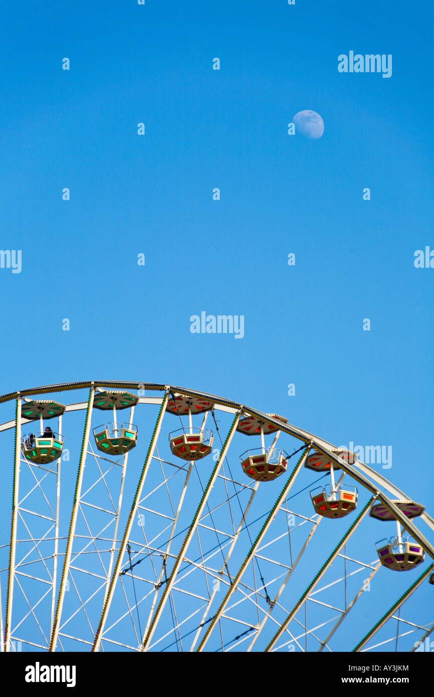 A ferris wheel with a blue sky and the moon in the background Stock ...