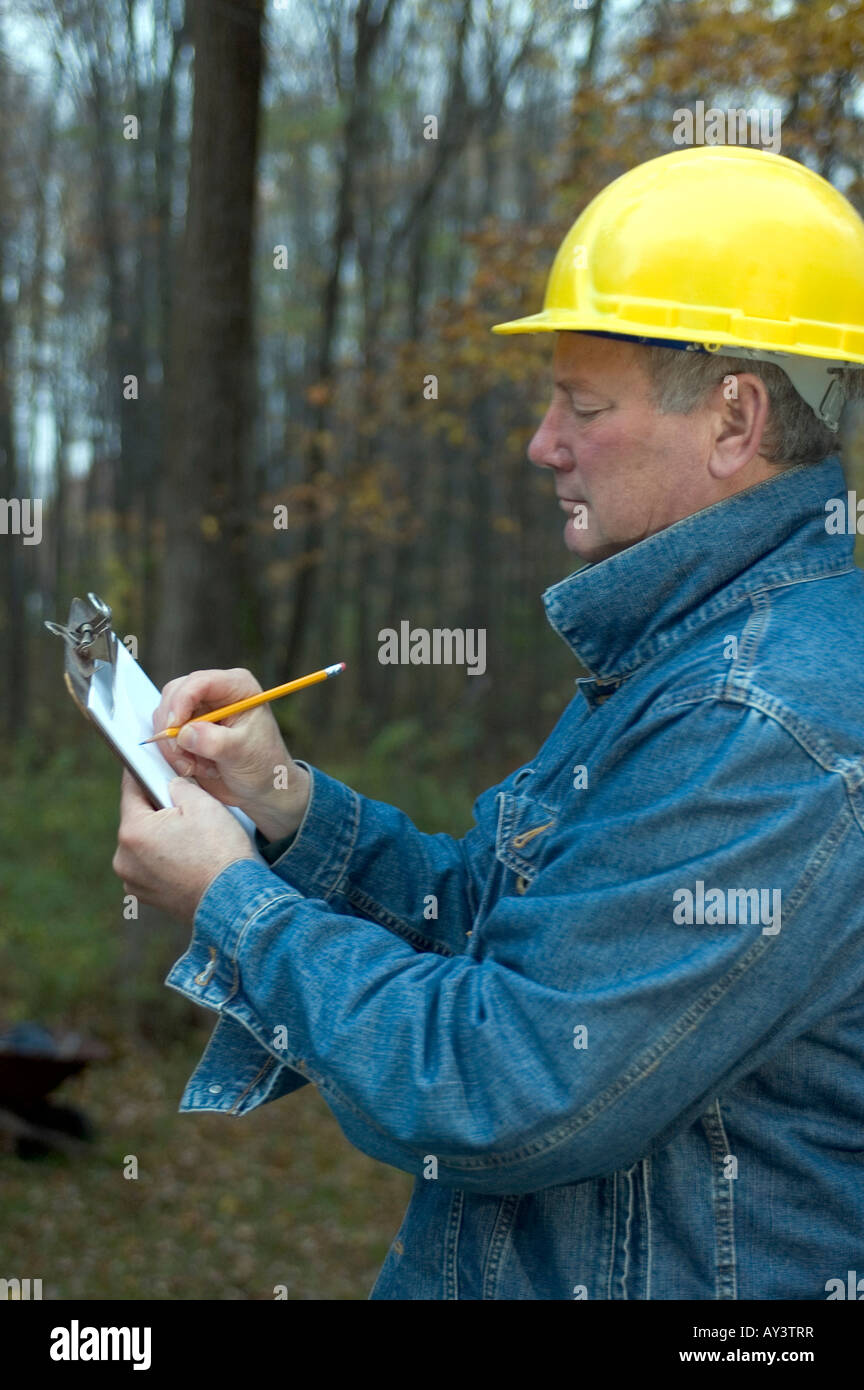 contractor handyman builder smiling confident happy on the job writing ...