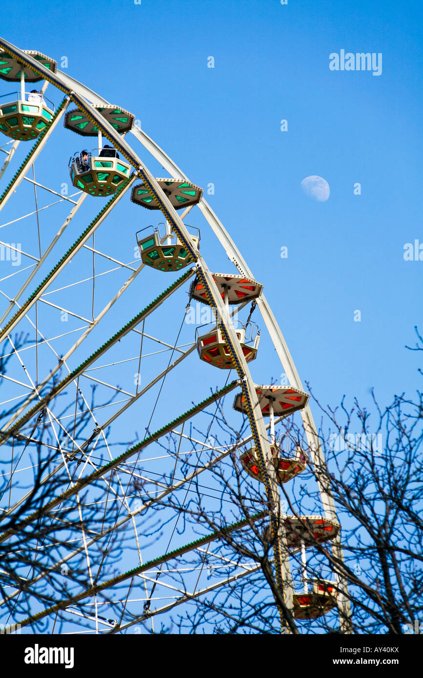 A ferris wheel with a blue sky and the moon in the background Stock ...