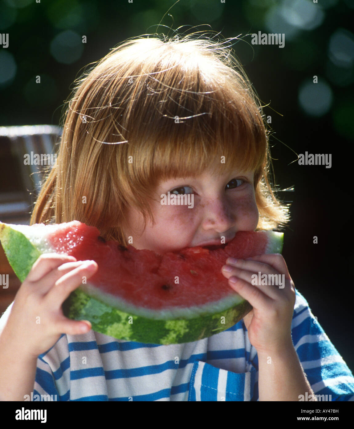child bites into a slice of watermelon Stock Photo - Alamy