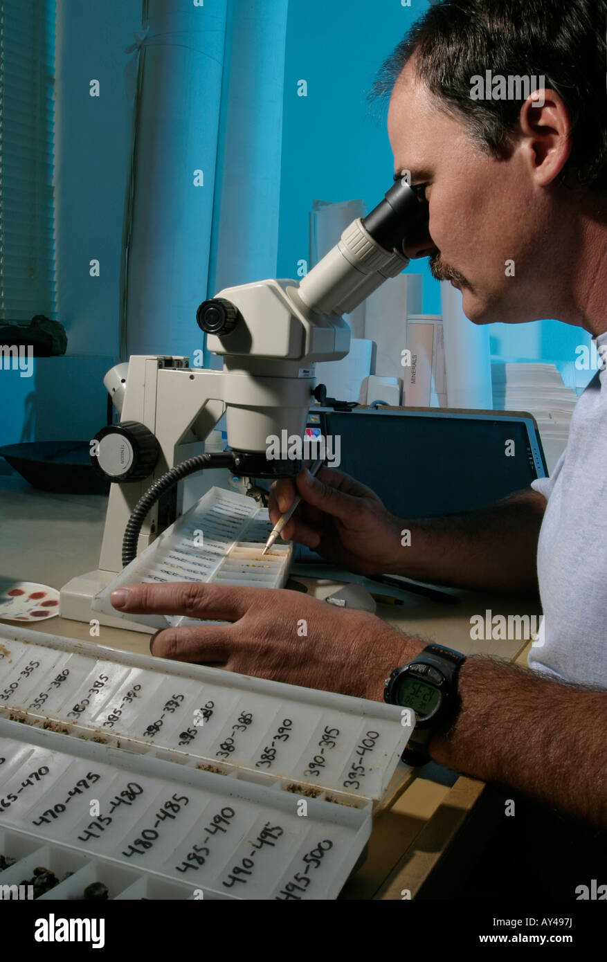 Geologist logging drill cuttings using a microscope to model the ...