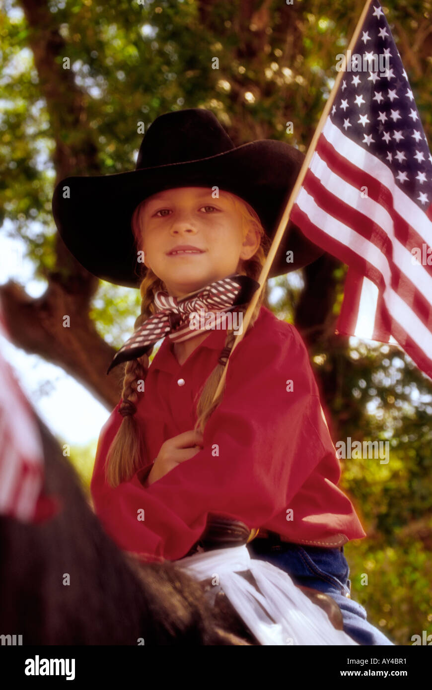 A young cowgirl rides her pony in the 4th of July parade in Capitan ...