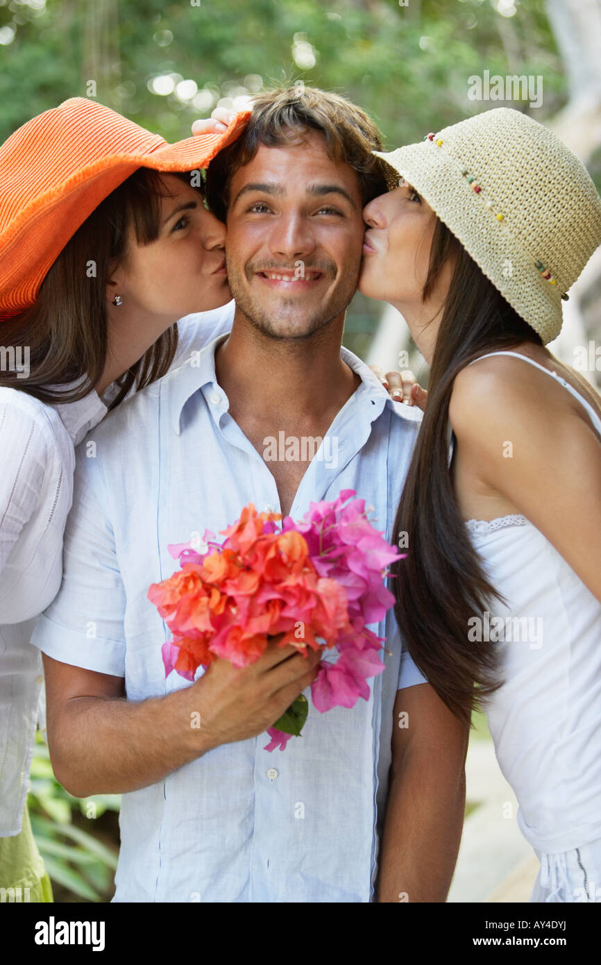 Two women kissing man on both cheeks Stock Photo - Alamy