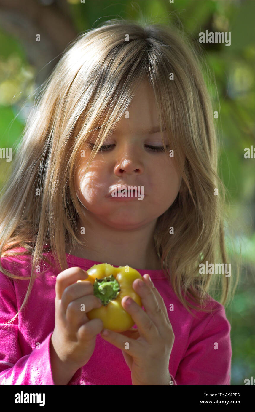 Little girl outdoors eating paprika Stock Photo - Alamy