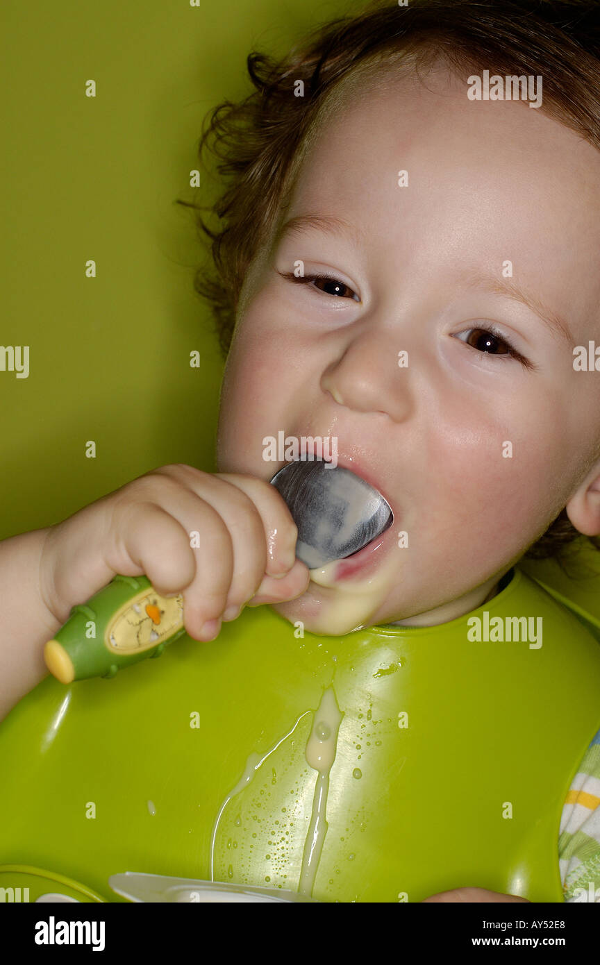BABY EATING CREAM WITH SPOON Stock Photo - Alamy