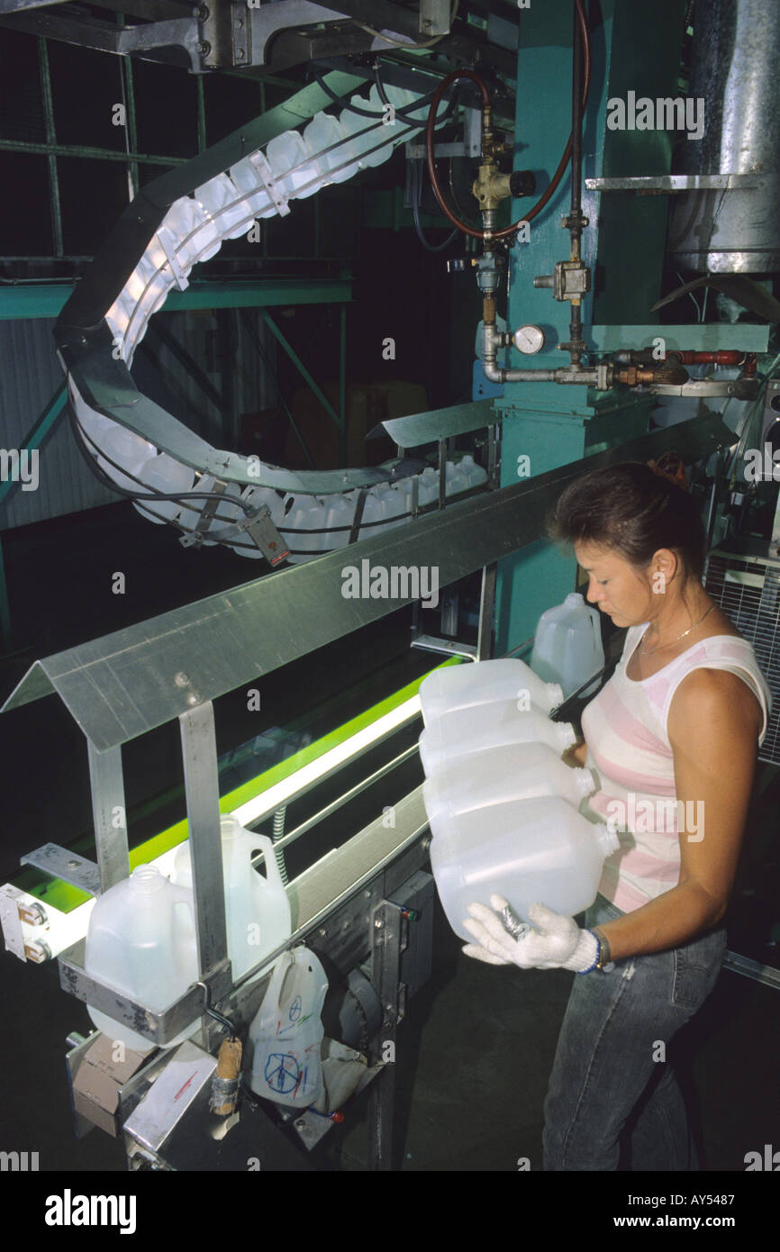 A woman employee works at a polyethylene bottle manufacturing plant ...