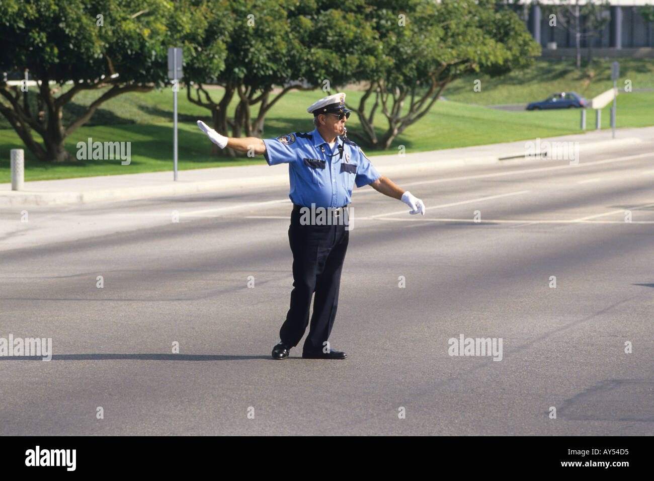 Male traffic officer blowing a whistle directing traffic in Los Angeles ...