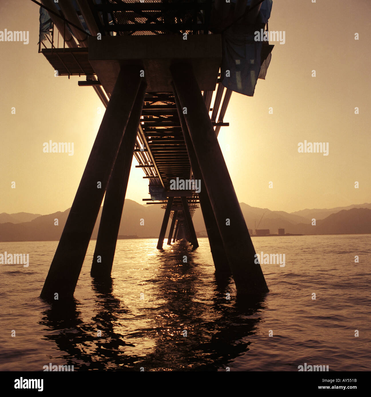 Sun setting over oil jetty looking towards oil terminal at Fujairah ...