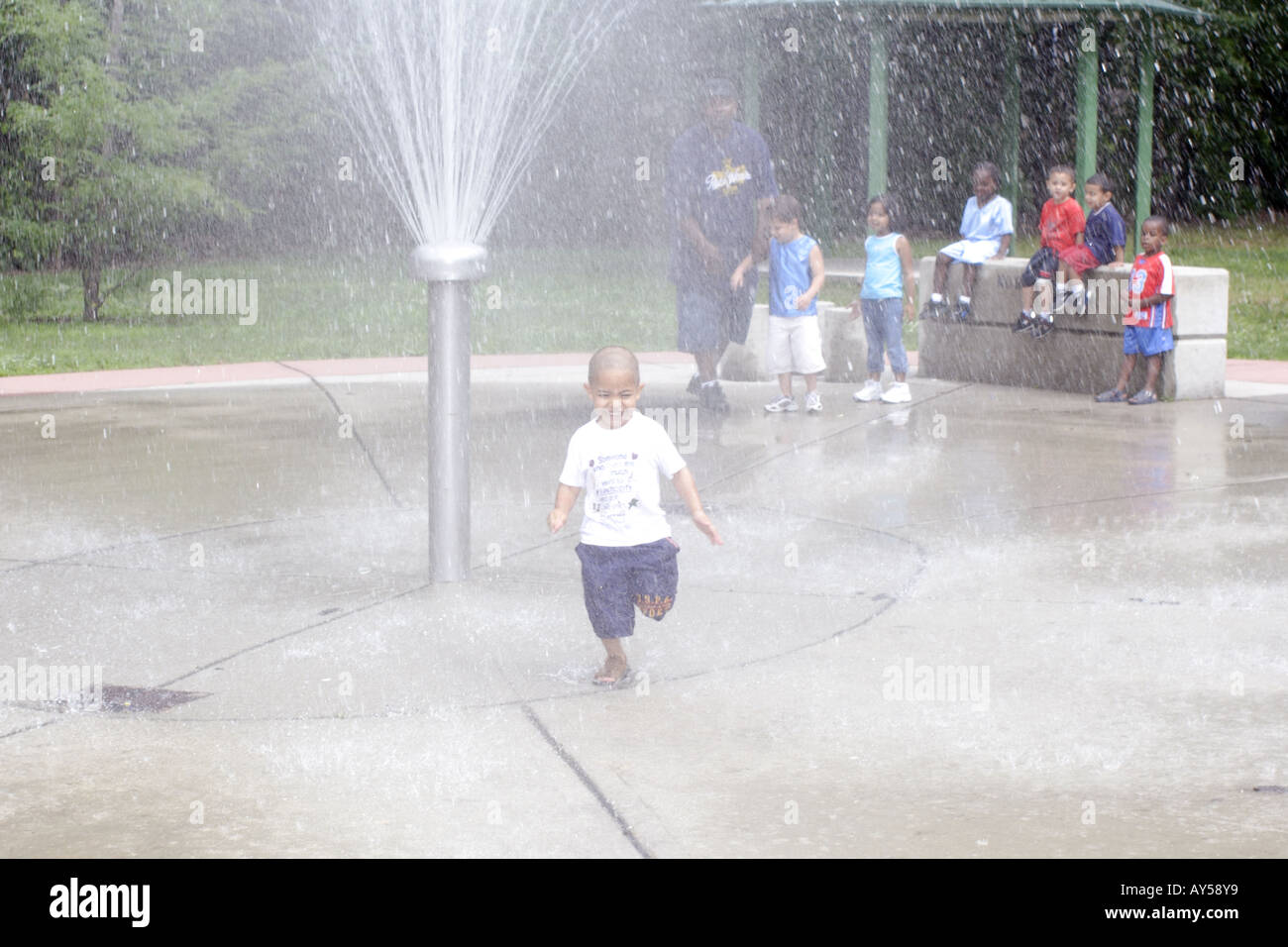 Kids running through sprinkler hi-res stock photography and images - Alamy
