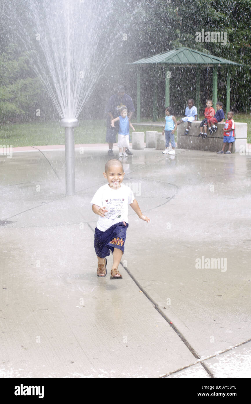 Kids running through sprinkler hi-res stock photography and images - Alamy