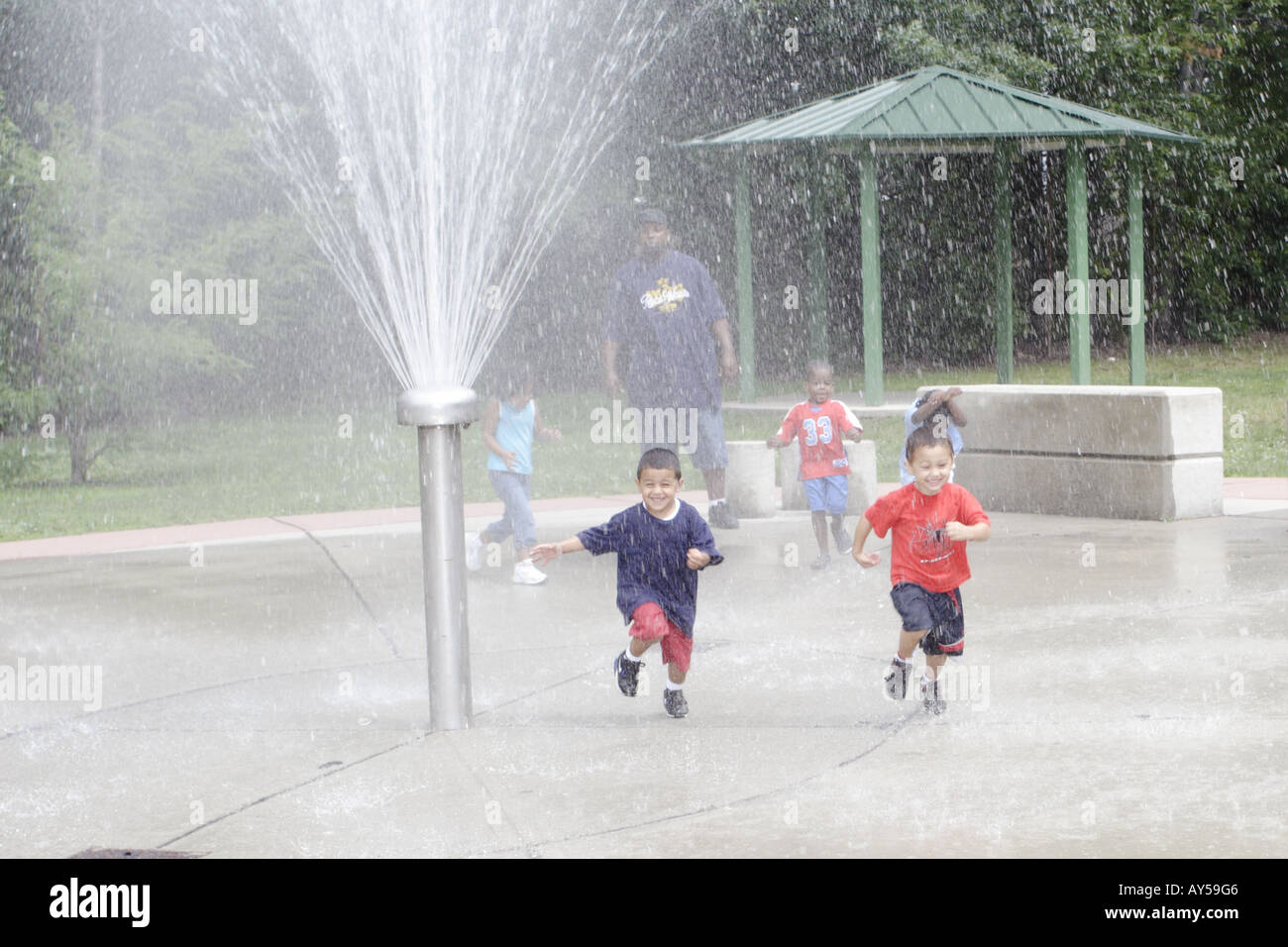Children running through sprinkler hi-res stock photography and images ...