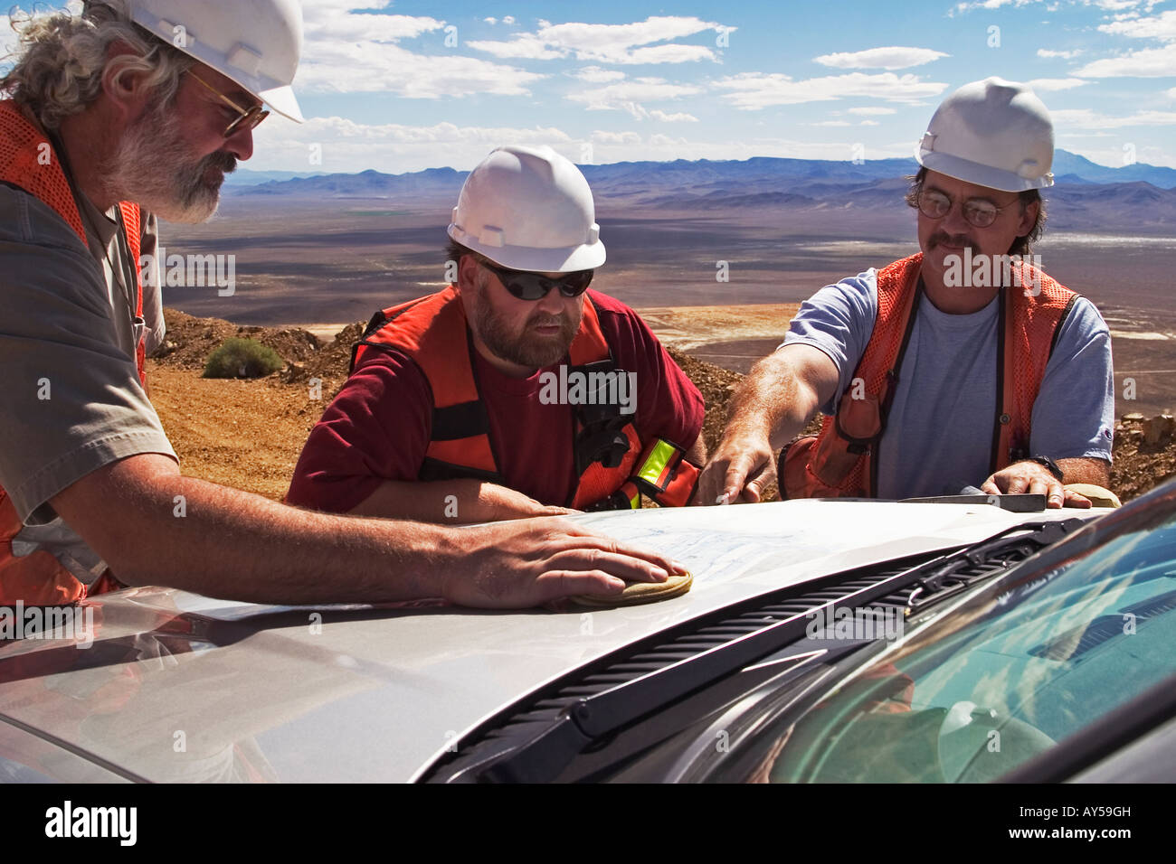 Geologists discussing exploration project on surface gold mine site ...