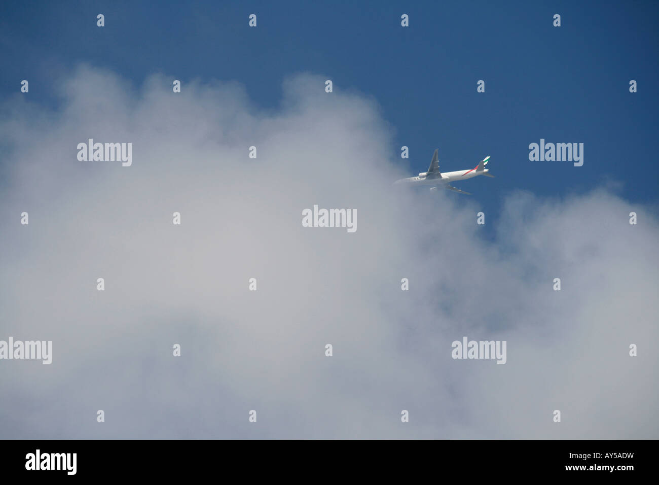 plane flying through white clouds in blue sky Stock Photo - Alamy