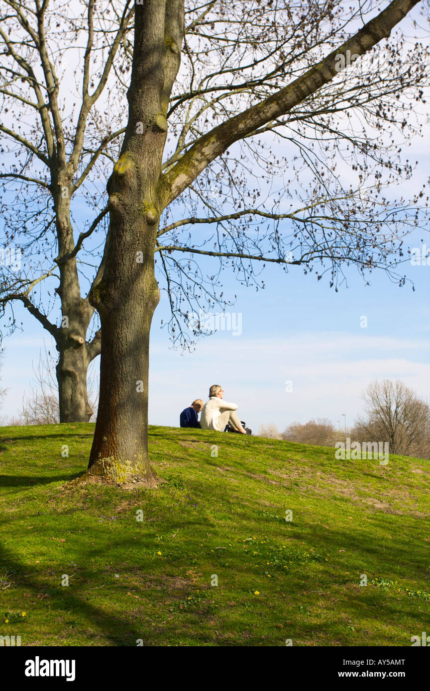 Couple of grandma and grandson sitting in a park under a tree Stock ...