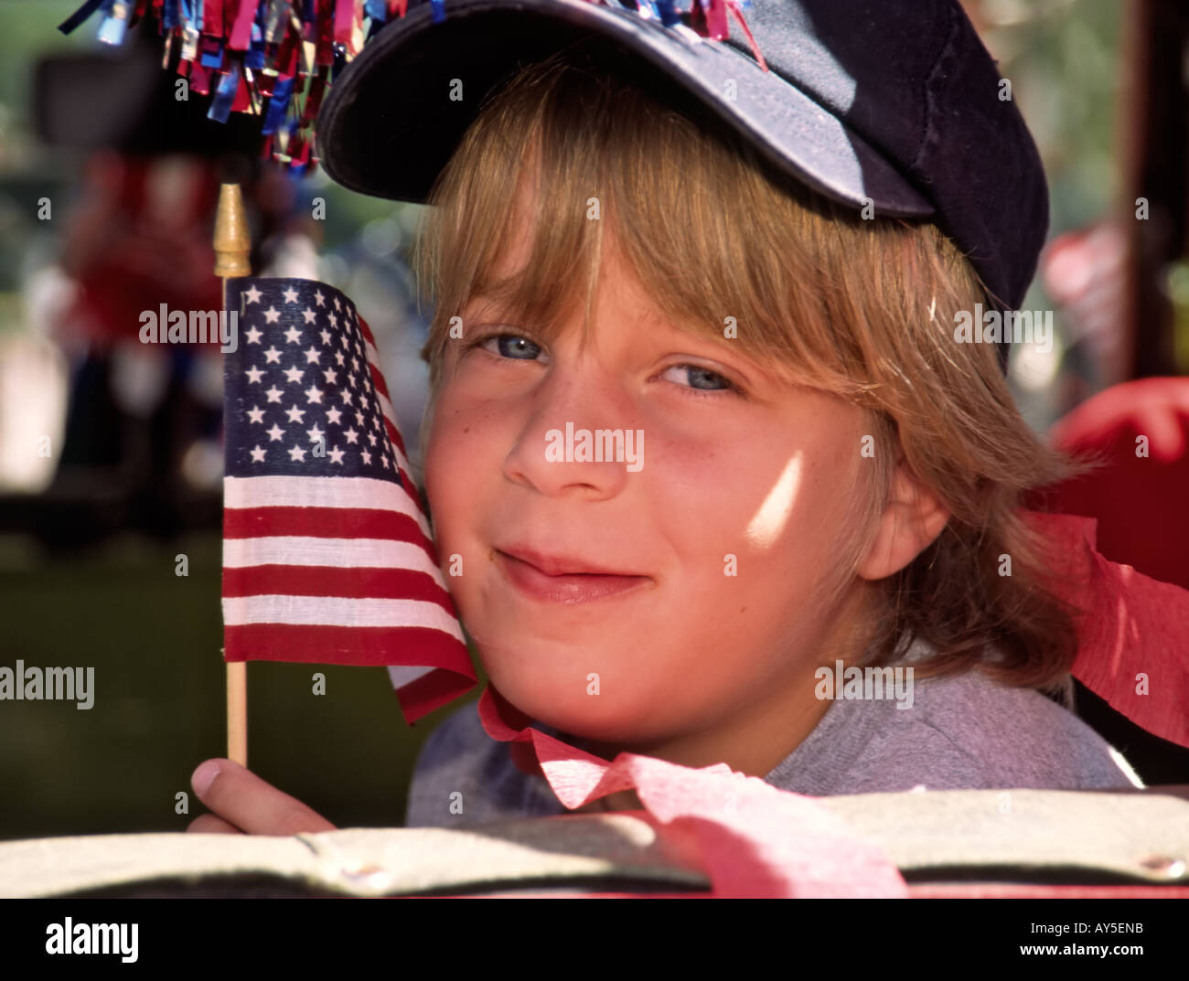 A young patriotic boy waves the American flag, at the 4th of July ...