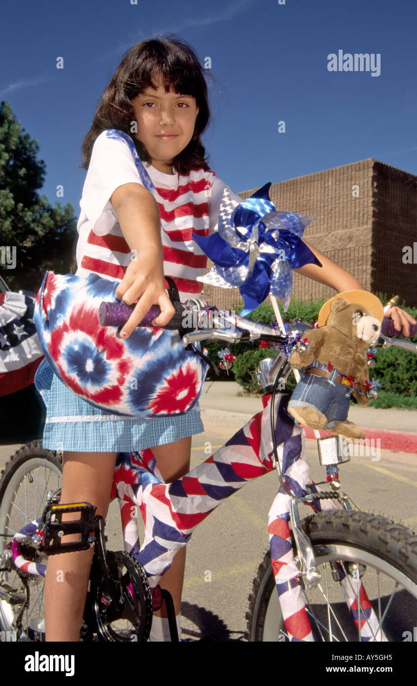 A patriotic girl rides her decorated bicycle, in the 4th of July parade in Capitan, New Mexico ...
