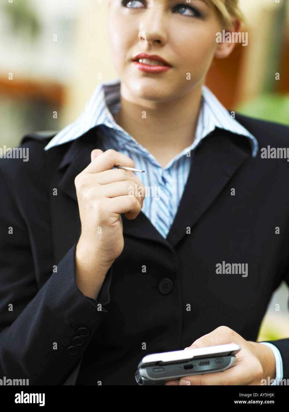 A young lady holding her PDA and bag Stock Photo - Alamy