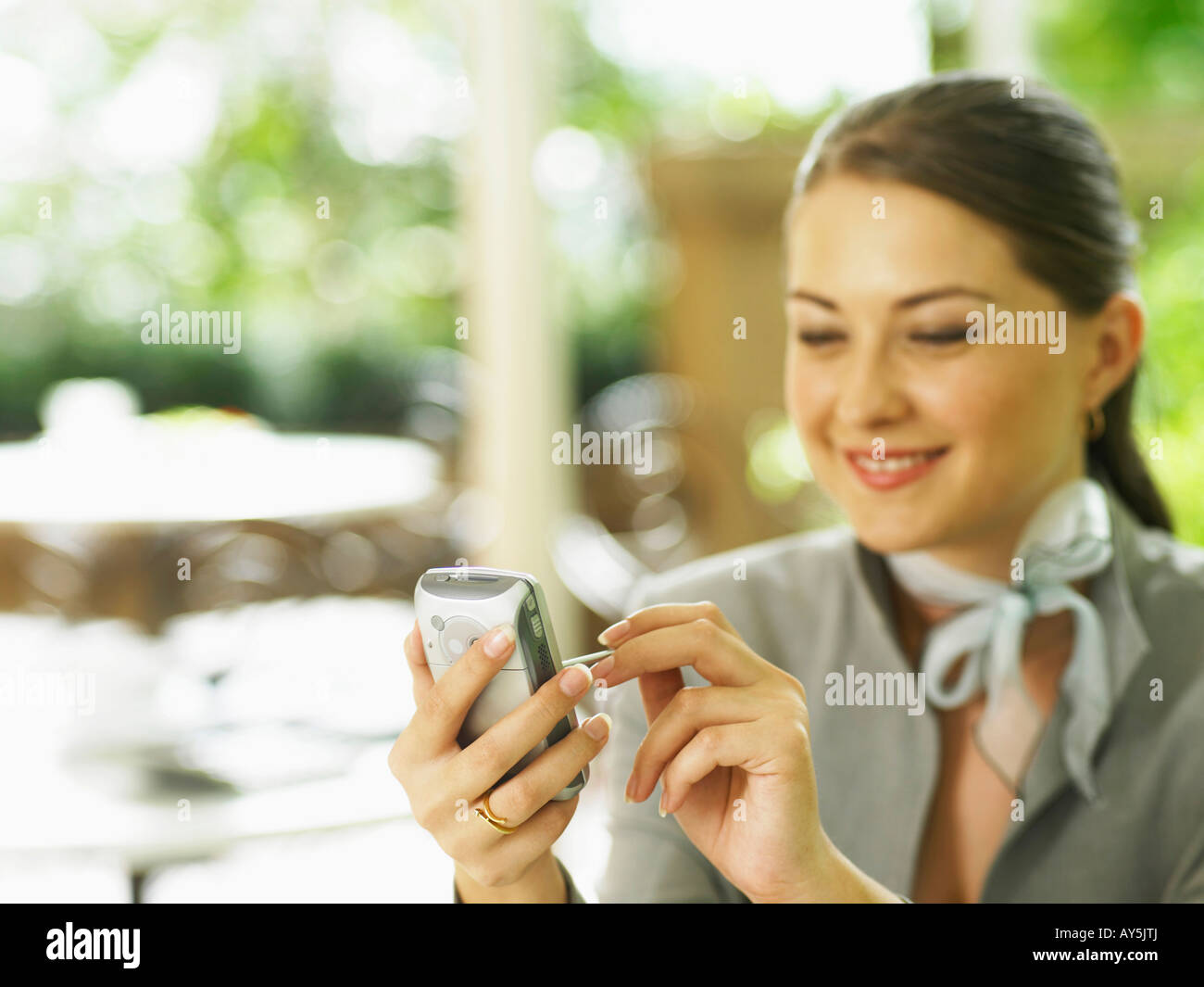 A young lady using her PDA at a cafe Stock Photo - Alamy