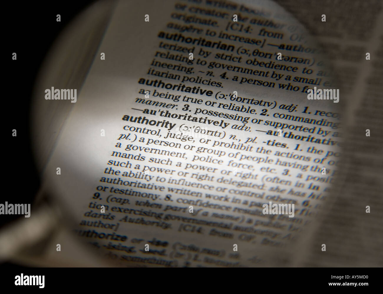 MAGNIFYING GLASS ON DICTIONARY PAGE SHOWING DEFINITION OF THE WORD ...